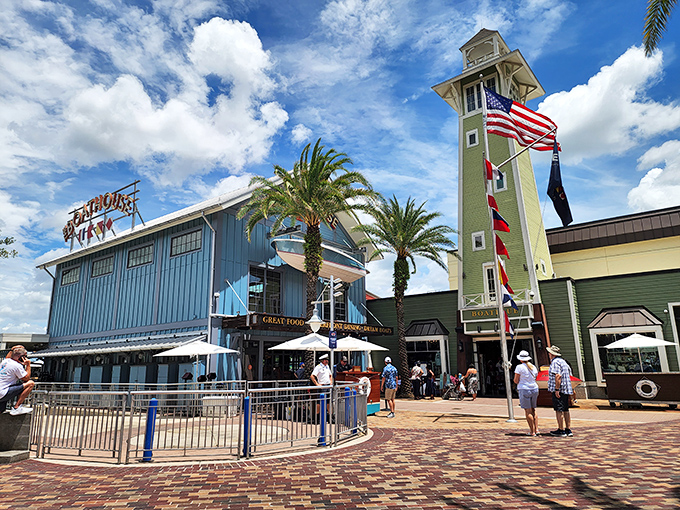 The Boathouse's striking blue exterior and lighthouse tower stand like a maritime beacon, promising seafood treasures within Disney Springs' waterfront haven.