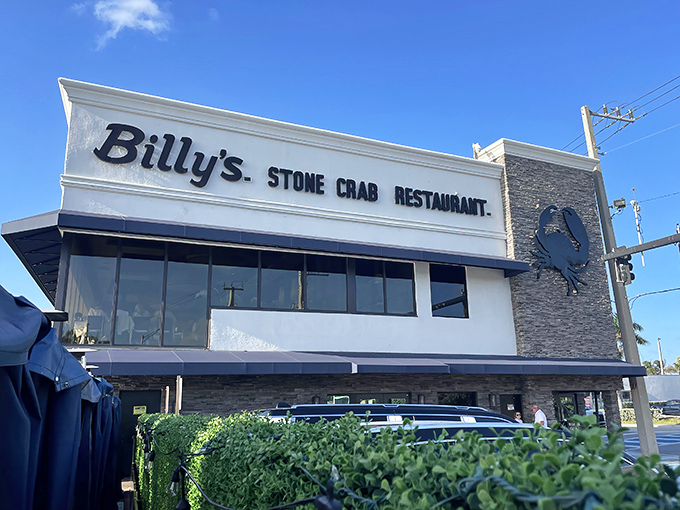 Billy's Stone Crab Restaurant stands proudly against the Florida sky, its iconic blue crab emblem promising seafood treasures within. Who knew steak perfection awaited behind those doors?