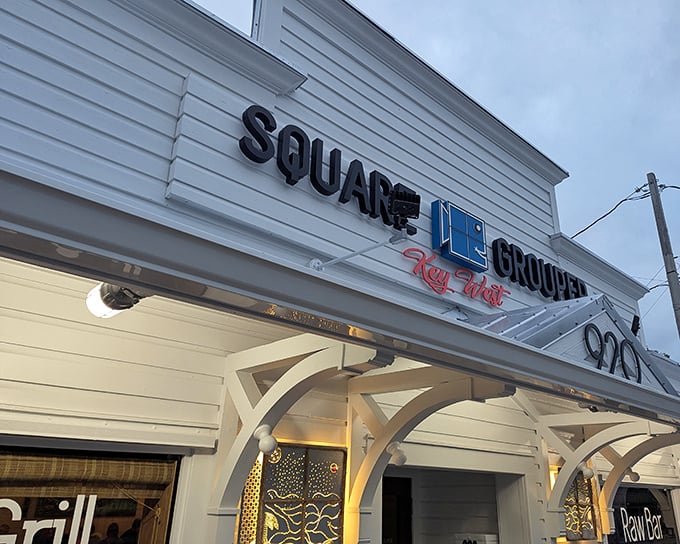 The blue neon sign of Square Grouper glows like a beacon for hungry travelers. Key West's culinary secret hiding in plain sight.