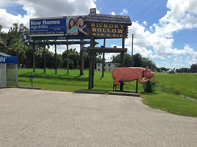 The iconic Hickory Hollow sign stands tall with its pink pig guardian below&mdash;a roadside beacon promising smoky delights and seafood surprises.