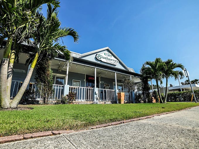 The quintessential Florida breakfast spot view&mdash;palm trees frame this cozy blue building where breakfast dreams come true seven days a week.