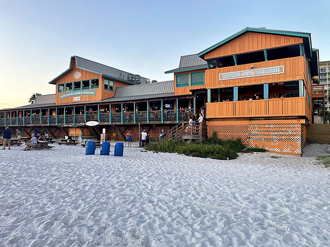 Beachfront paradise or seafood heaven? At Dewey Destin's, you don't have to choose. The weathered orange-brown exterior sits proudly on sugar-white sand, promising maritime delights within.