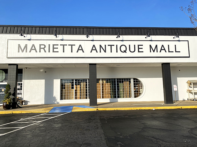 The unassuming storefront of Marietta Antique Mall belies the treasure trove within. Like a time portal disguised as a strip mall tenant, it beckons curious explorers.