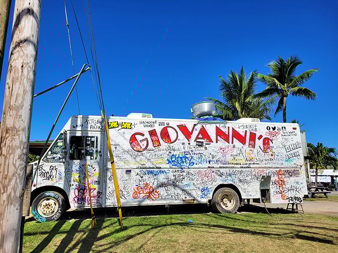 The world's most delicious guestbook on wheels. Giovanni's iconic white truck stands proudly against Hawaii's blue sky, every inch covered in visitors' signatures.