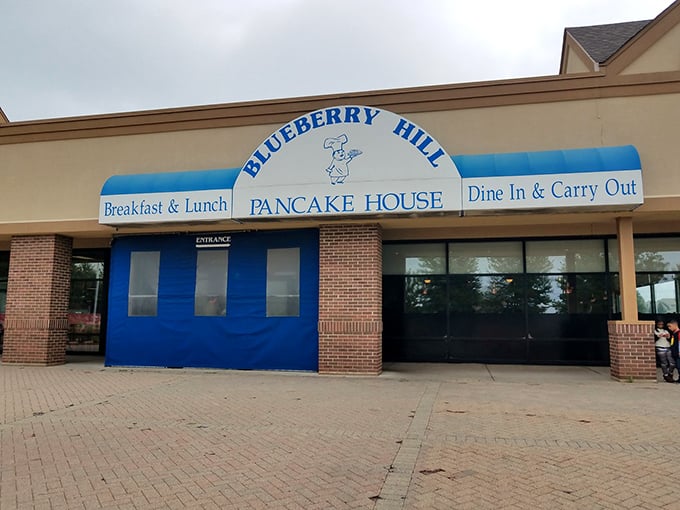 The iconic blue awning of Blueberry Hill Pancake House stands out like a breakfast beacon in Aurora, promising pancake paradise to all who enter.