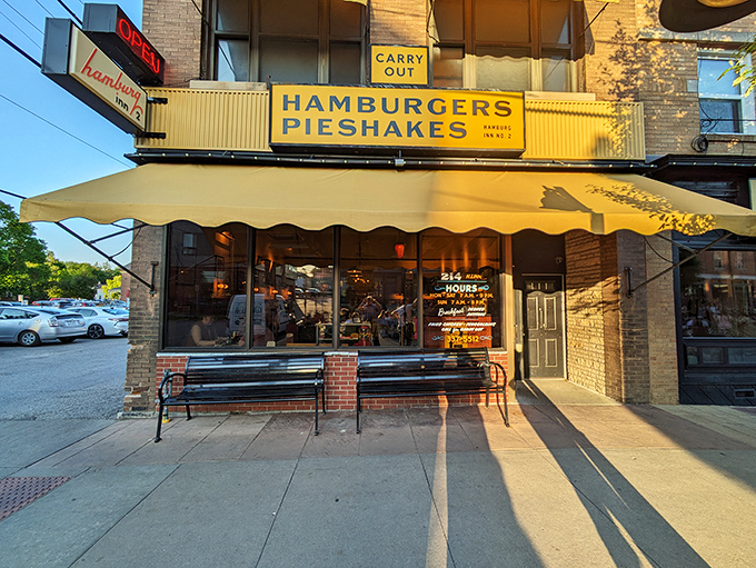 Sunshine yellow meets brick-and-mortar nostalgia at Hamburg Inn's entrance, where the "HAMBURGERS PIESHAKES" sign has been luring hungry Iowans for generations.