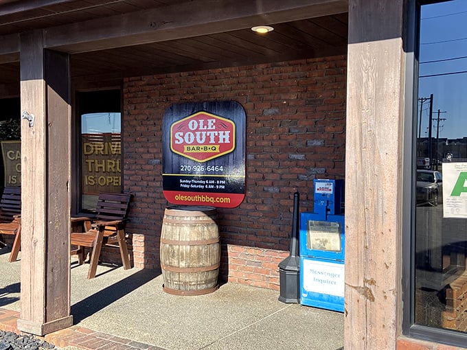 The brick exterior of Ole South BBQ welcomes hungry travelers with rustic charm, a wooden barrel, and the promise of smoky delights within.