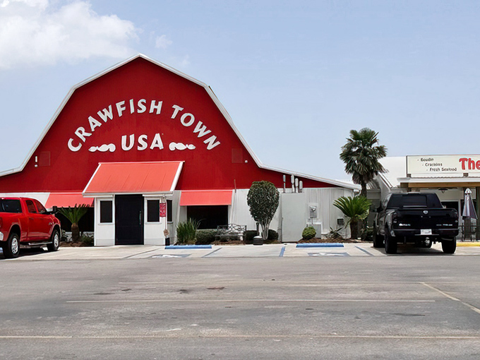 The iconic red barn of Crawfish Town USA stands proudly against the Louisiana sky, like a culinary lighthouse guiding hungry travelers home.