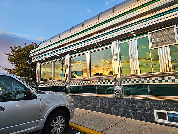 The gleaming stainless steel exterior of Broadway Diner catches the sunset, promising comfort food and nostalgia inside this Baltimore institution.