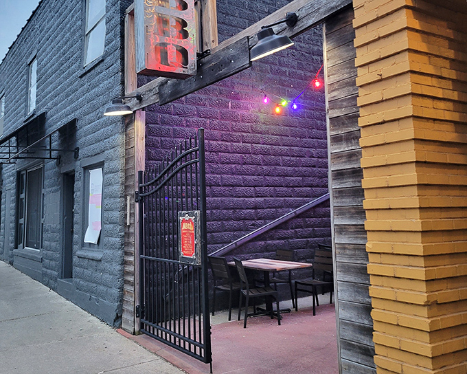 A hidden courtyard sanctuary where barbecue dreams come true. String lights, green umbrellas, and the promise of meat perfection await.