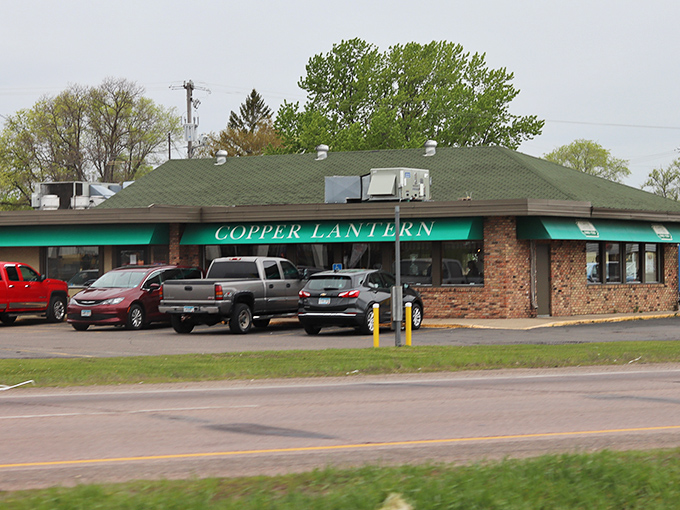 The unassuming brick exterior of Copper Lantern stands like a beacon of breakfast hope in St. Cloud, those green awnings promising comfort within.