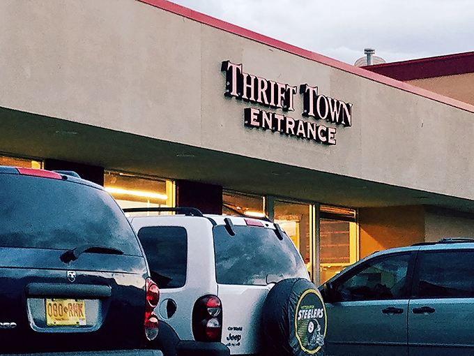 The iconic red Thrift Town sign beckons like a lighthouse for bargain hunters navigating the sea of retail sameness.