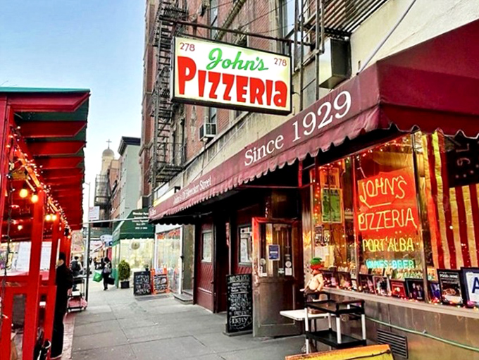 The iconic red awning of John's Pizzeria stands as a beacon of hope for the pizza-obsessed, proudly declaring "No Slices" since 1929.