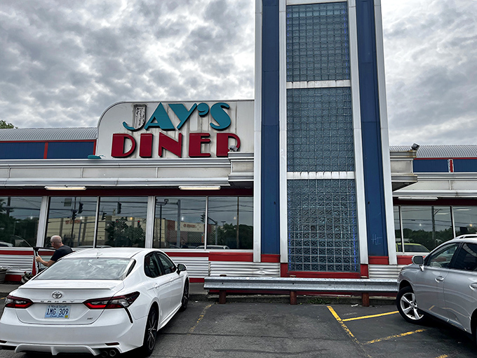 The iconic blue and red exterior of Jay's Diner stands like a time capsule against Rochester's skyline, beckoning hungry travelers with its retro charm.