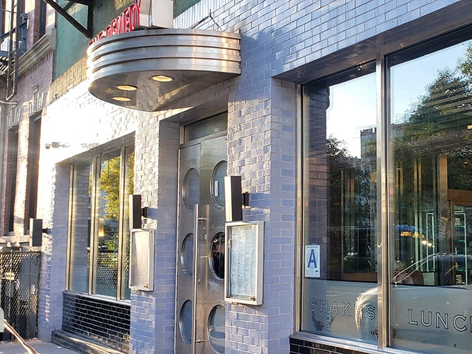 The iconic blue-tiled exterior of Remedy Diner catches afternoon light, its vintage marquee promising comfort food salvation on the Lower East Side.
