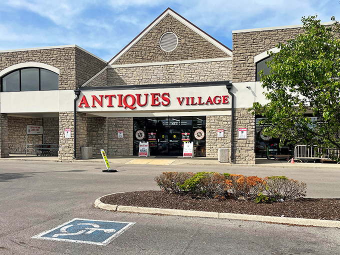 The stone facade of Antiques Village beckons treasure hunters with its bold red signage – like a lighthouse for the nostalgically inclined.