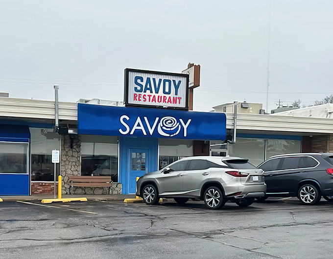 The iconic blue awning of Savoy Restaurant stands as a breakfast beacon on Tulsa's Sheridan Road, promising morning magic within.