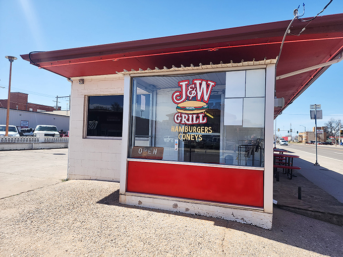The iconic red and white exterior of J&W Grill stands as a time capsule of Americana, beckoning hungry travelers with its simple promise of burgers and coneys since 1957.