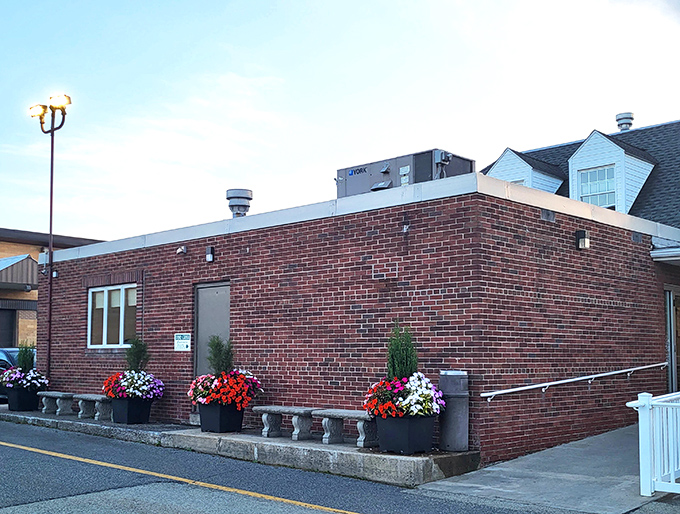 The brick exterior of Pine Grill showcases colorful flower planters, adding a touch of warmth to this Somerset culinary landmark.