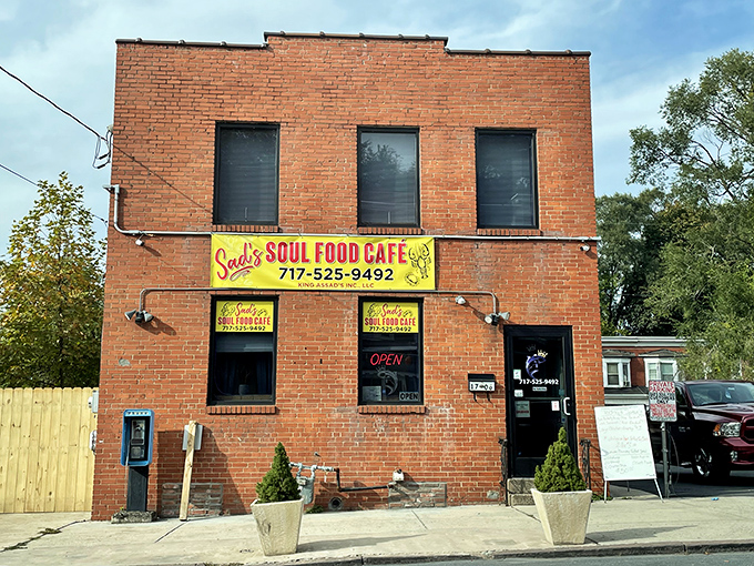 The unassuming brick exterior of Sad's Soul Food Cafe stands like a sentinel of flavor, promising culinary treasures behind that bright yellow sign.