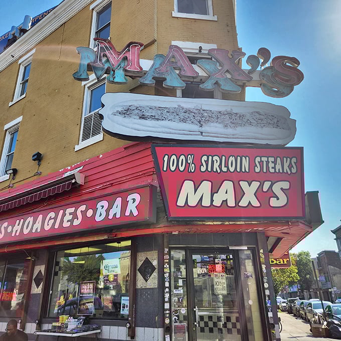 The iconic Max's Steaks sign glows like a neon North Star for sandwich pilgrims, promising "100% SIRLOIN STEAKS" with all the subtlety of a Philly sports fan.