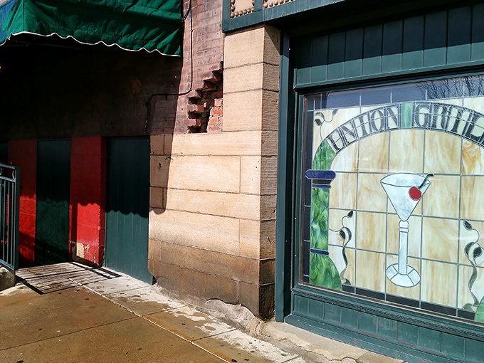 The iconic stained glass window at Union Grill beckons like a lighthouse for hungry travelers, promising cocktails and comfort in equal measure.