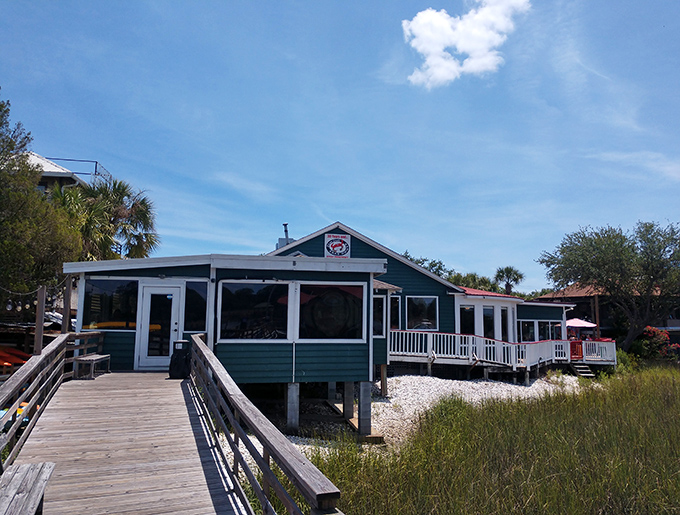 The teal-colored coastal charm of Shem Creek Crab House beckons seafood lovers like a siren song with palm trees providing the perfect South Carolina welcome.