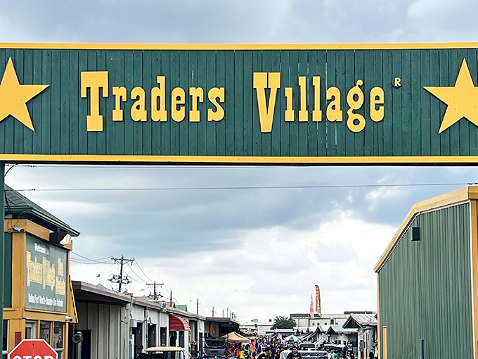 The iconic green and yellow entrance to Traders Village stands like a portal to bargain heaven, complete with Texas stars announcing you've arrived somewhere special.
