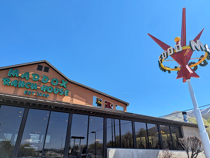 The iconic Maddox Ranch House glows against the Utah sky, its neon cowboy sign a beacon for hungry travelers seeking beef nirvana.