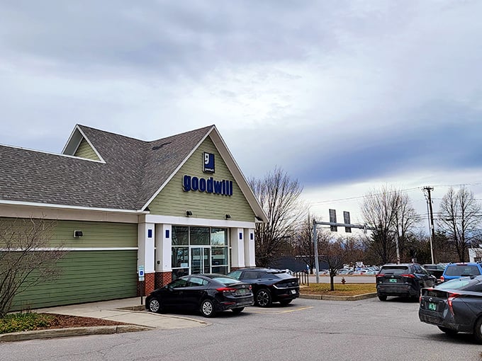 The green-sided Goodwill building stands like a beacon of bargain hope under Vermont skies, promising treasures within for the patient hunter.
