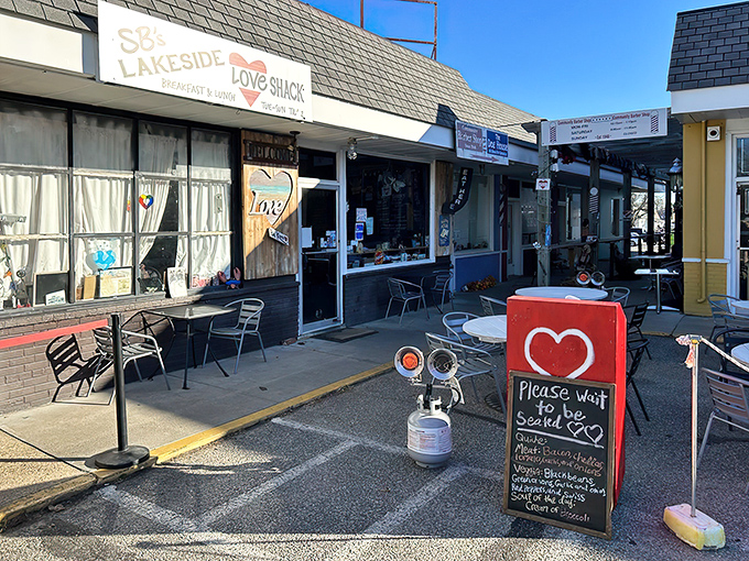 The unassuming blue exterior of SB's Lakeside Love Shack beckons with colorful outdoor tables and a promise of comfort food that transcends its modest storefront.