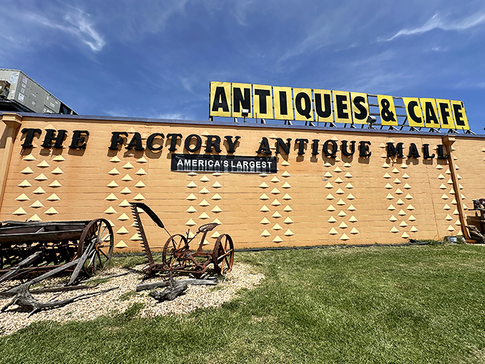 The iconic fa&ccedil;ade of Factory Antique Mall proudly announces itself as "America's Largest," with vintage farm equipment setting the nostalgic tone before you even step inside.