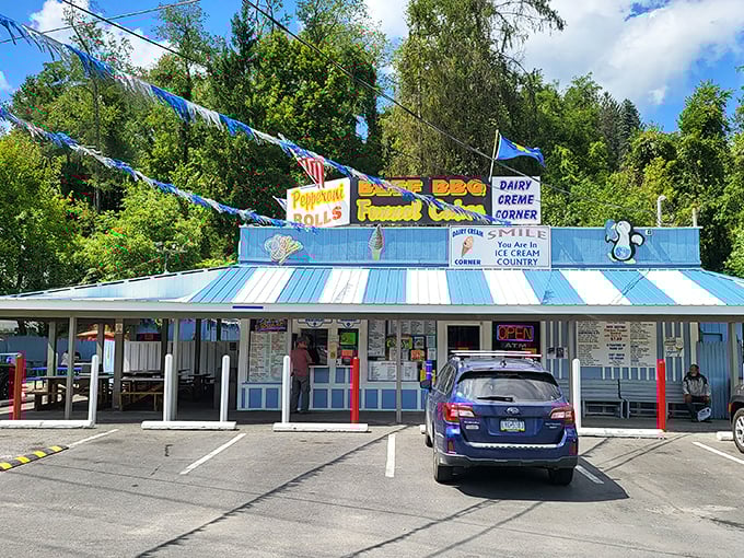 The blue-striped roof and colorful pennants of Dairy Creme Corner stand like a beacon of joy on East Fairmont Avenue, promising sweet relief from everyday worries.