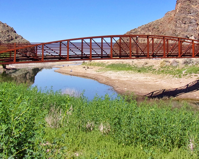 The rusty-red bridge spans across Echo Canyon's waters like a scene from a Western film &ndash; rugged beauty in perfect harmony.