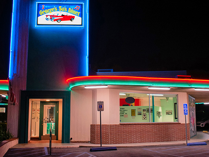 By night, George's neon sign becomes a beacon for hungry night owls, its vibrant colors illuminating the promise of midnight pancakes and timeless American comfort.