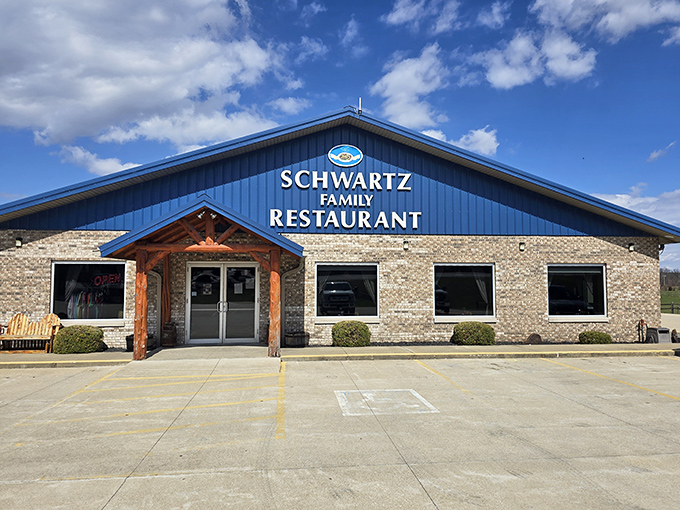 The blue-roofed beacon of Schwartz Family Restaurant stands proudly against Indiana's sky, promising comfort food salvation for hungry travelers.