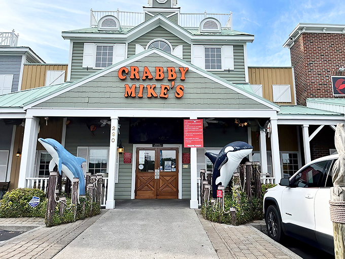 The seafood promised land beckons with its coastal charm. Crabby Mike's facade, complete with dolphin and penguin sentinels, invites hungry pilgrims to worship at the altar of crab legs.