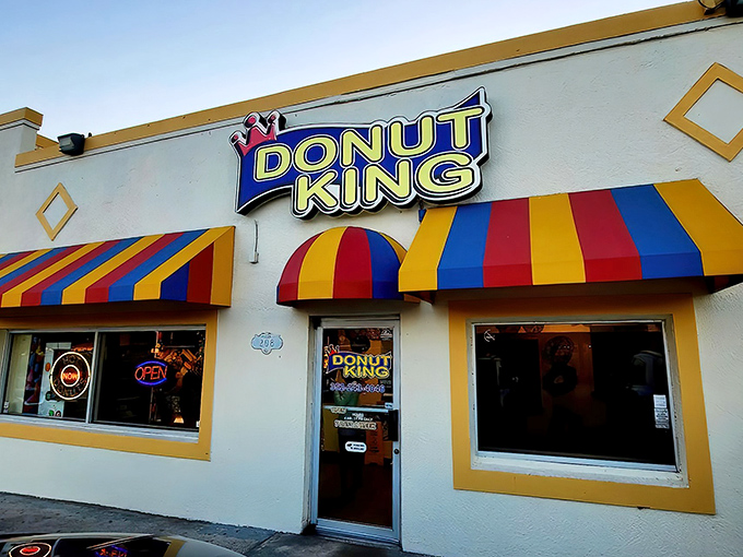 Sunset casts a golden glow on Donut King's cheerful exterior, transforming this humble shop into a beacon for those seeking early morning salvation in fried dough.
