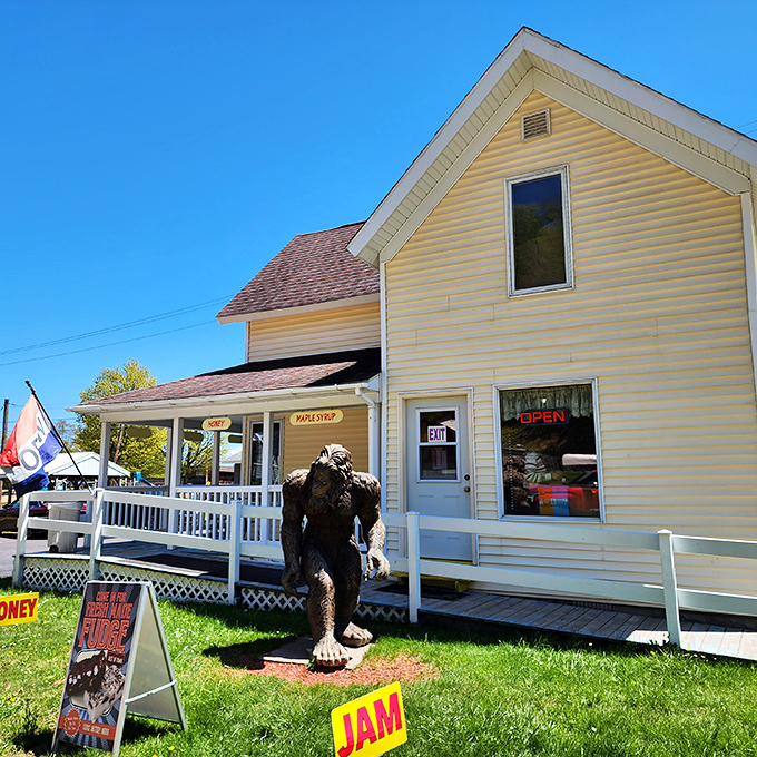 The classic yellow farmhouse exterior of Muldoons stands proudly against Michigan's blue sky, complete with a Bigfoot statue guarding the pasty treasures within.