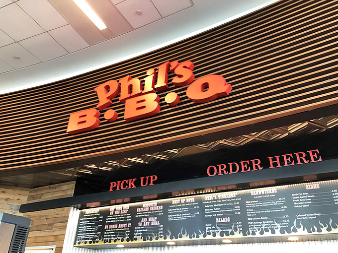 The iconic Phil's BBQ sign beckons hungry visitors like a neon-lit barbecue bat signal. Resistance is futile, surrender to the smoke.