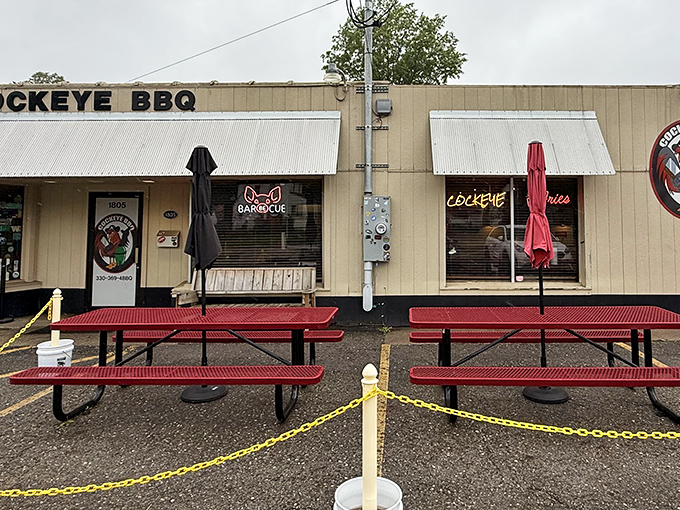 The unassuming exterior of Cockeye BBQ proves once again that in barbecue, flashy facades are inversely proportional to meat quality. Those red picnic tables await your smoky adventure.