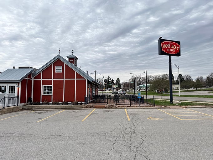 The iconic red barn exterior of Jimmy Jack's stands like a barbecue beacon, promising smoky delights within its rustic walls.