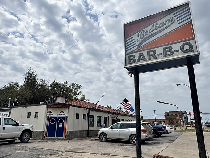 The unassuming exterior of Bedlam BAR-B-Q stands like a barbecue beacon against the Oklahoma sky, promising smoky treasures within those blue doors.