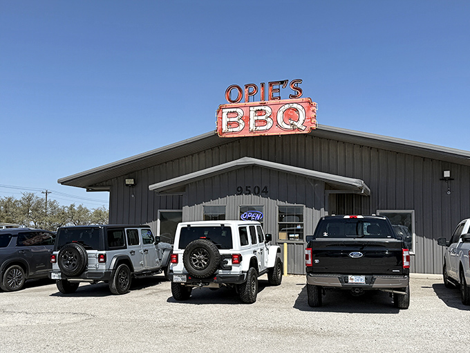 That iconic orange sign against the Texas sky is like a beacon for hungry travelers. Trucks in the parking lot? Always a good sign at a BBQ joint.