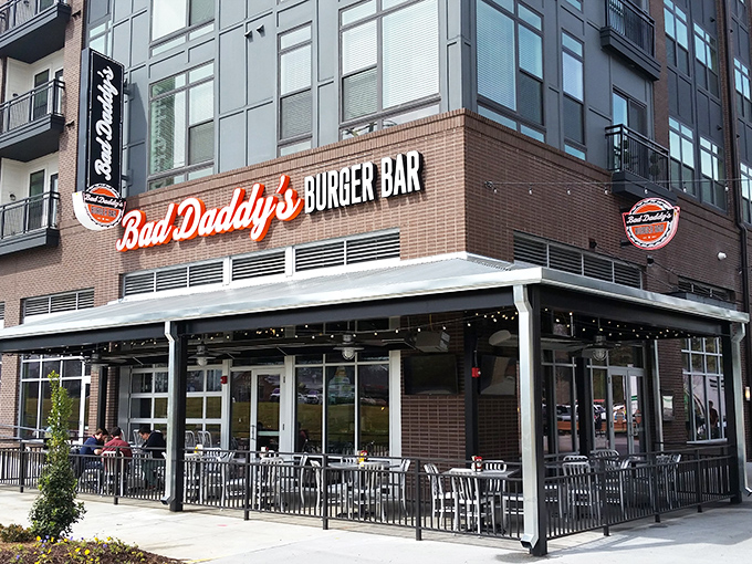 The glowing red neon sign of Bad Daddy's beckons like a lighthouse for the hungry, promising burger salvation in Chamblee's modern cityscape.