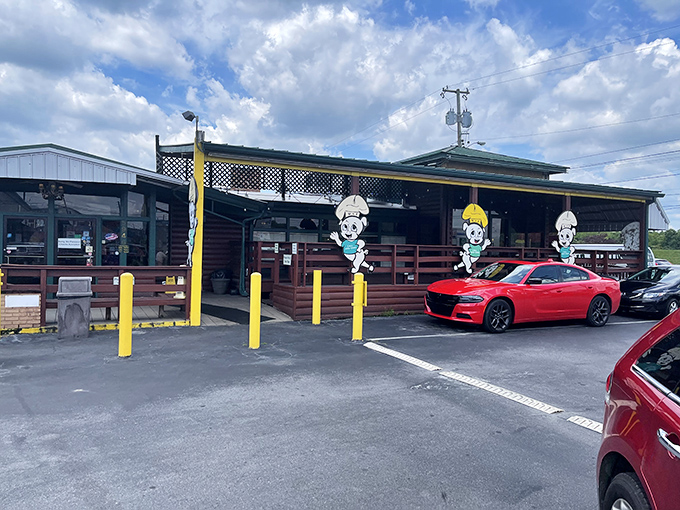 The log cabin exterior of Rib & Loin welcomes hungry travelers with its cheerful chef mascot and yellow safety poles standing guard like sentinels protecting barbecue treasure.