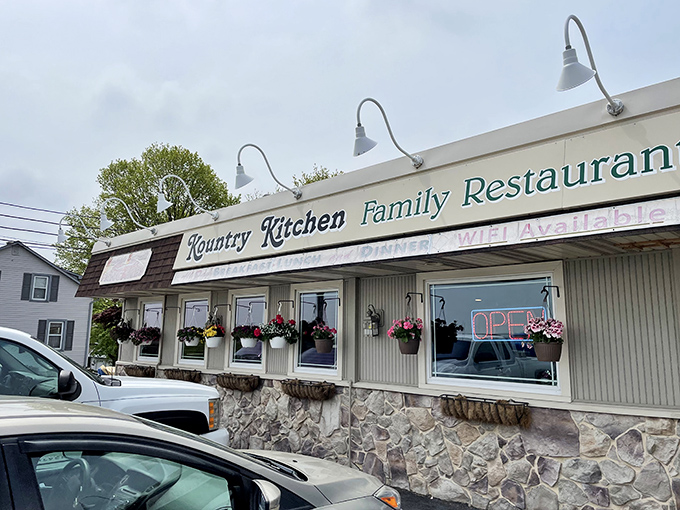 The stone facade and hanging flower baskets say "grandma's house," but the neon "OPEN" sign whispers "get in here and eat something wonderful."