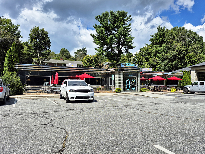 From the parking lot, Troy's 105 Diner beckons with its classic silver-and-blue facade, where red umbrellas hint at outdoor seating for those rare moments when eating isn't the main attraction.