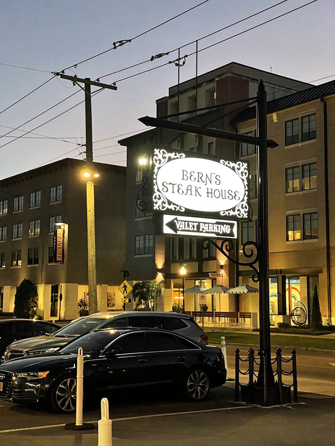 As evening falls, Bern's sign glows with promise, beckoning hungry travelers toward a legendary dining experience. The night's culinary adventure begins right here.