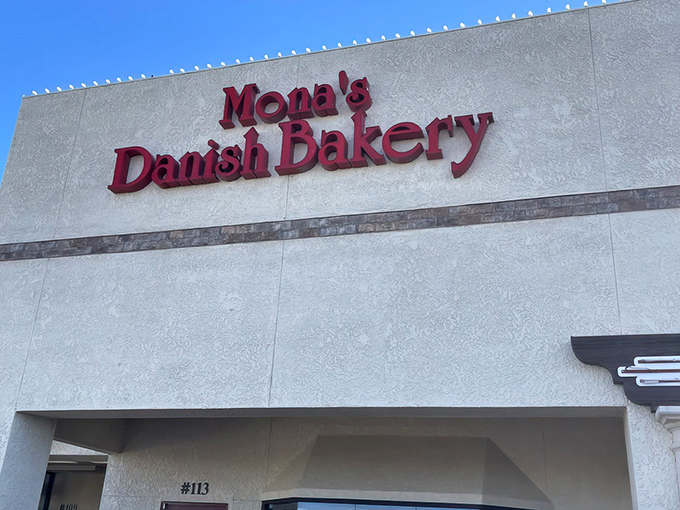 The bold red lettering against the cream-colored exterior isn't just signage&mdash;it's a beacon of hope for carb enthusiasts seeking Danish delights in the Arizona desert.
